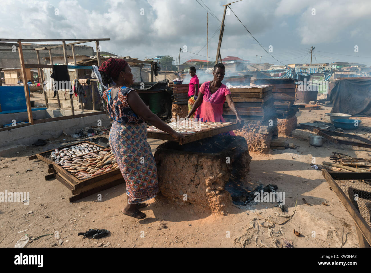 Two women smoking fish over a clay oven, Jamestown Fishing Village ...