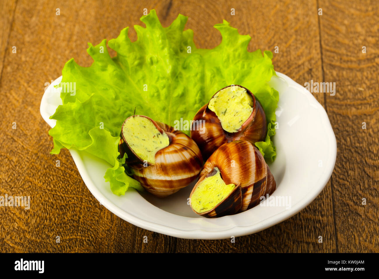 Escargot with cheese cream on salad leaves Stock Photo - Alamy