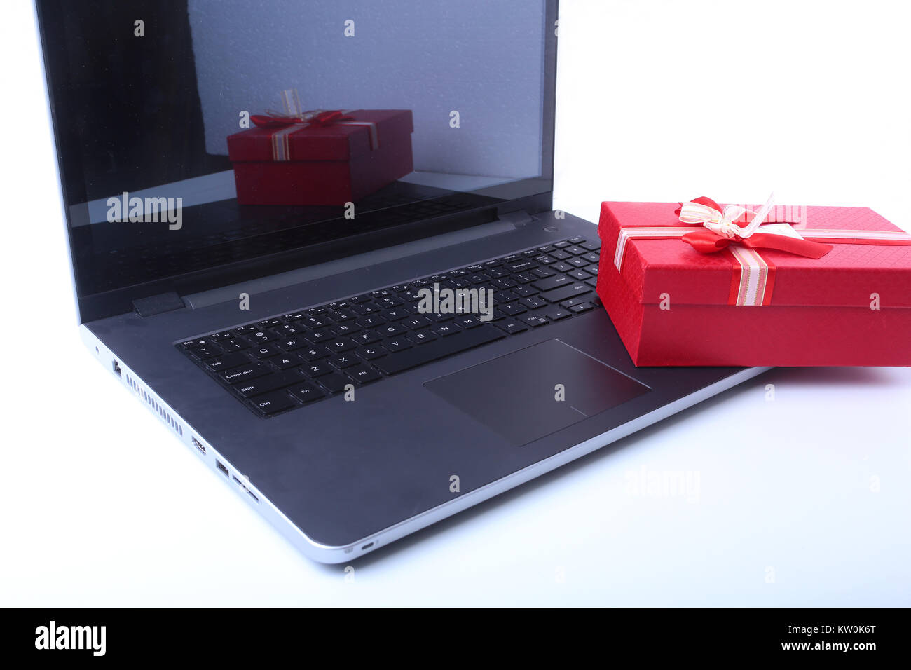 Laptop and christmas gifts box on white desk Stock Photo - Alamy