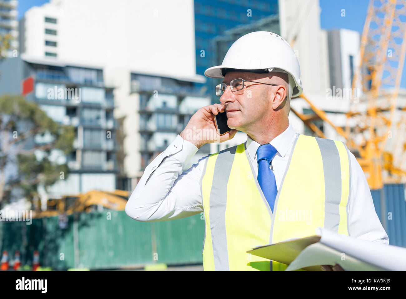Man architector outdoor at construction area having mobile conversation ...