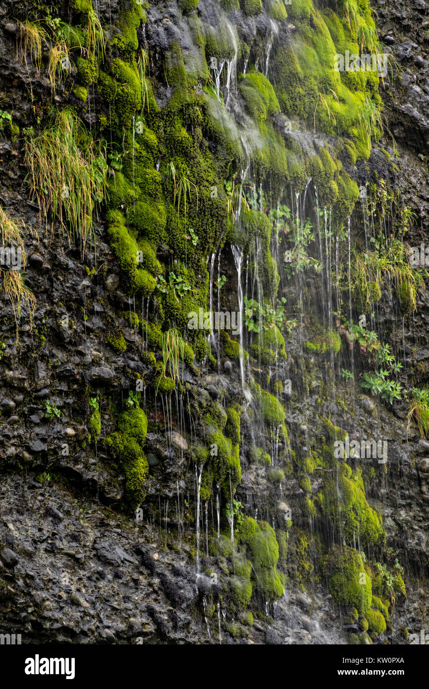A small waterfall cascades down the rock cliffs along the Cook Inlet at ...