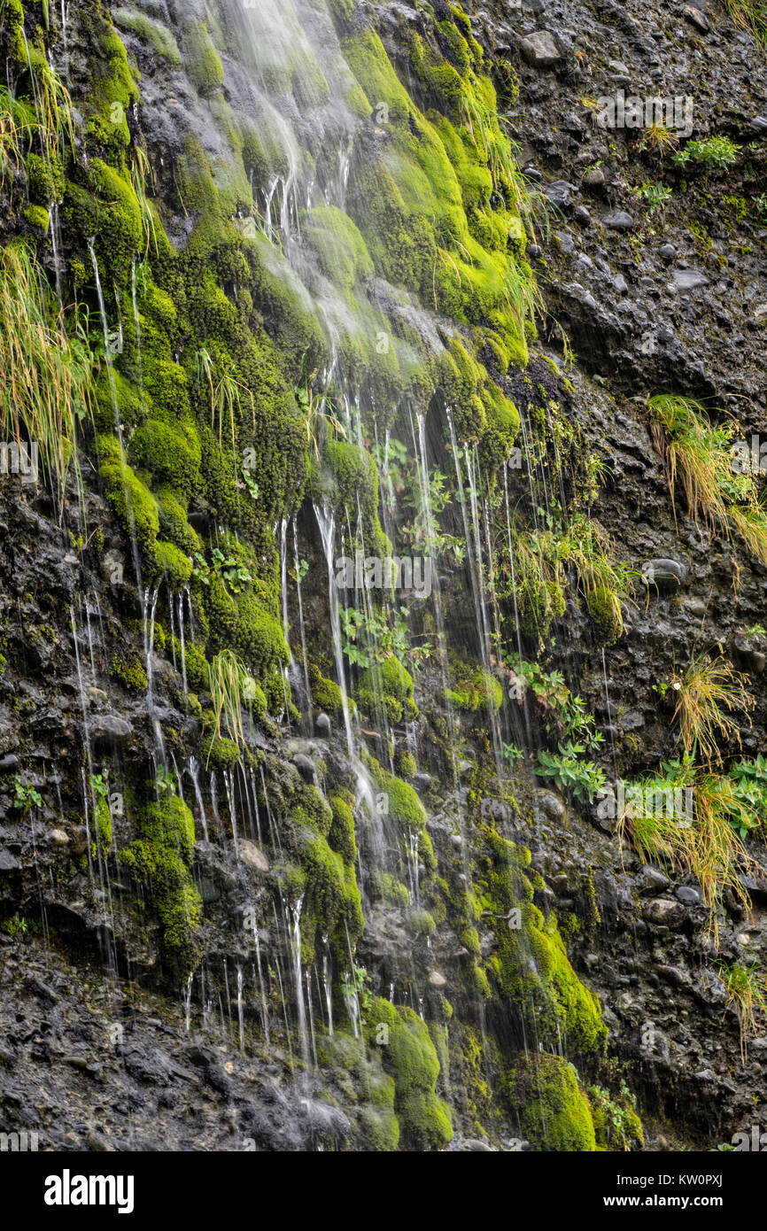 A small waterfall cascades down the rock cliffs along the Cook Inlet at ...