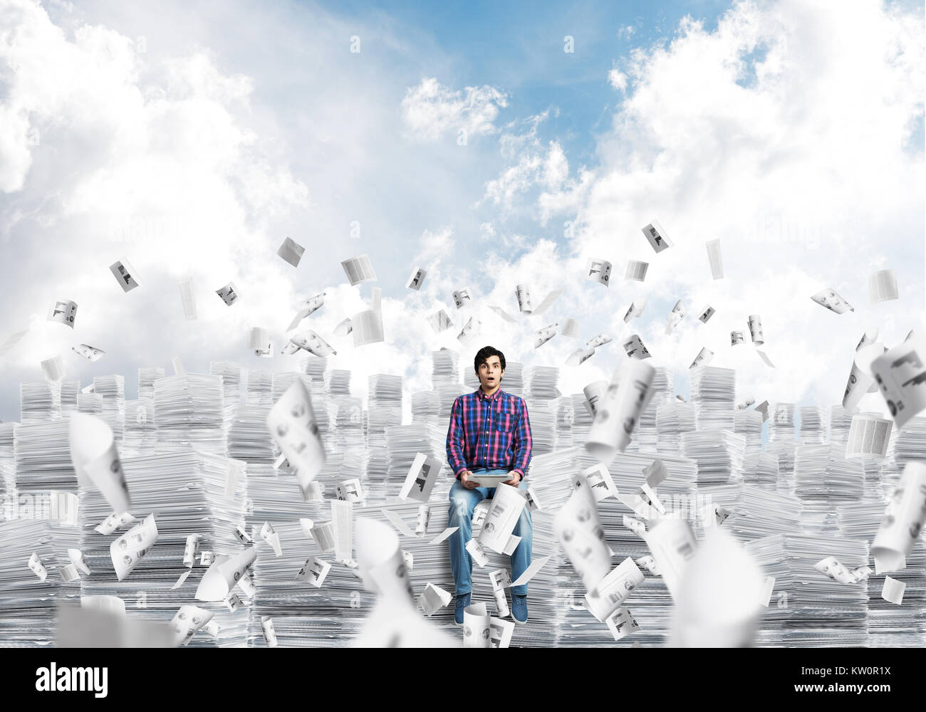 Attractive man sitting on pile of paper documents Stock Photo - Alamy