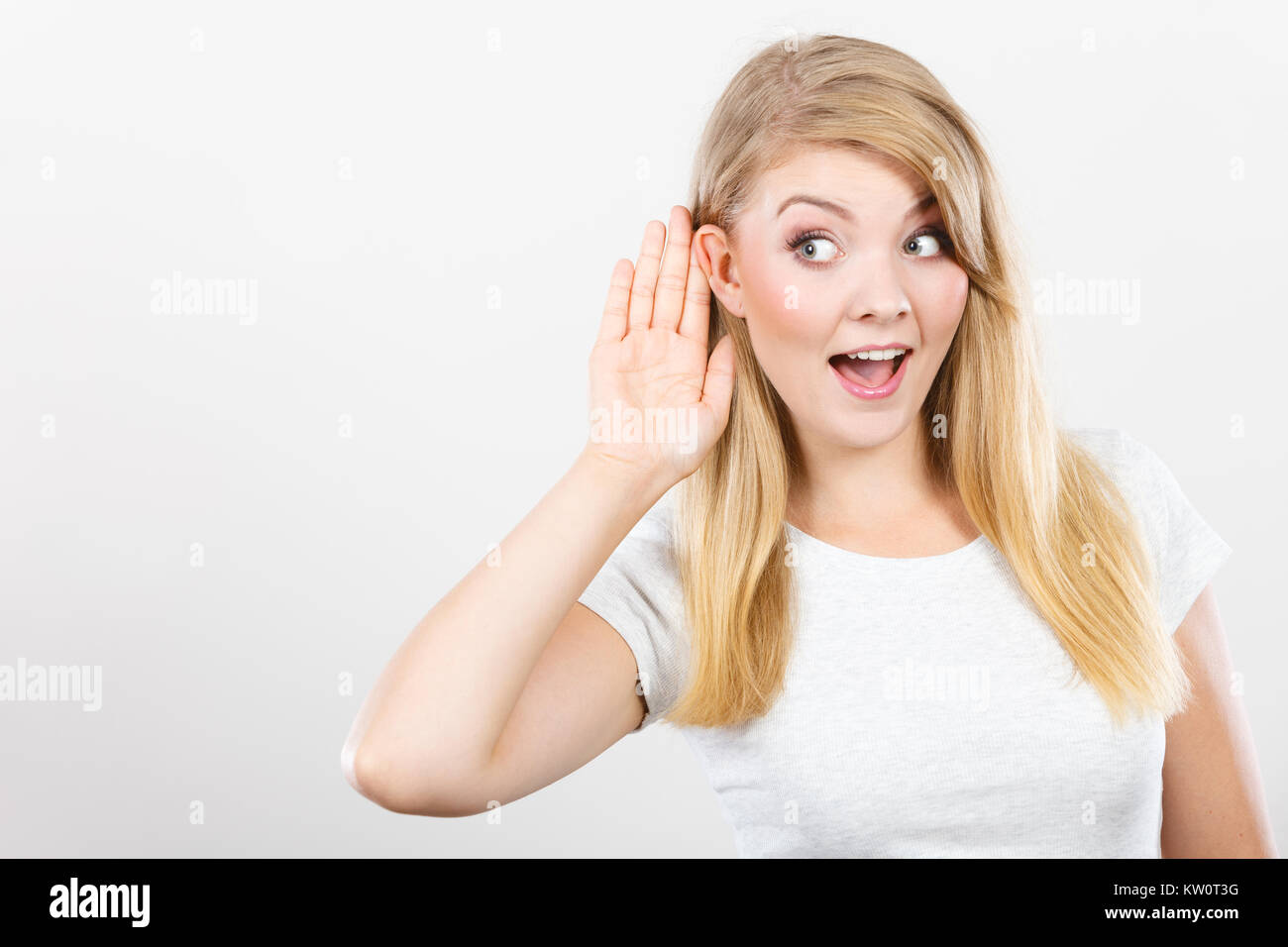 Gossip,rumors, whisper, hearing concept. Young blonde Woman putting ...