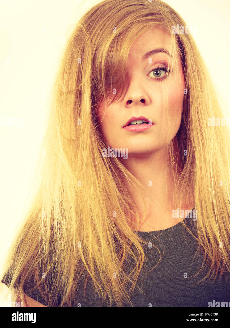 Bad hairstyle concept. Sad blonde woman with messy hair looking tired ...