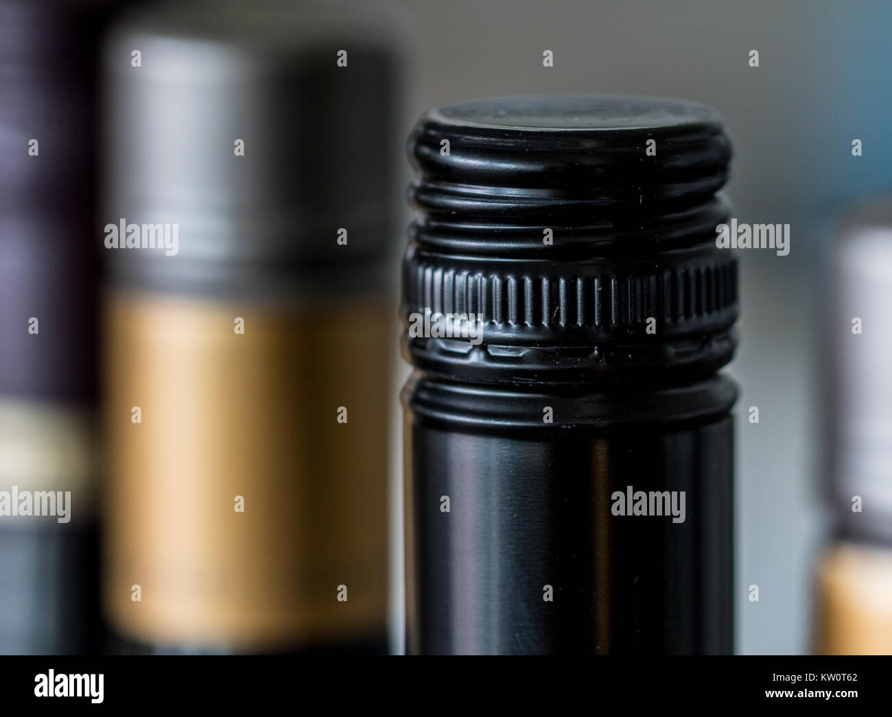 Close up of the tops of bottles in a row Stock Photo - Alamy