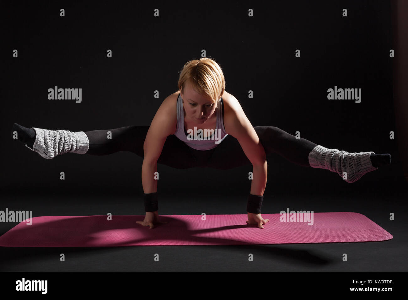 Young woman practicing yoga, Tittibhasana / Insect / Firefly Pose Stock ...