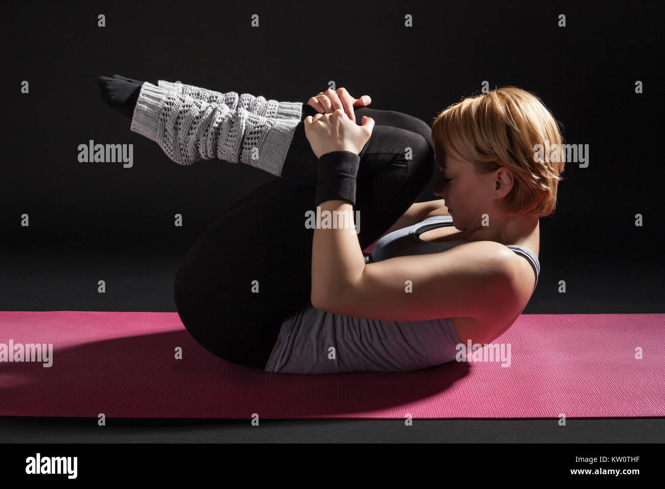 Young woman practicing yoga, Pawanmuktasana / Wind Relieving pose Stock ...