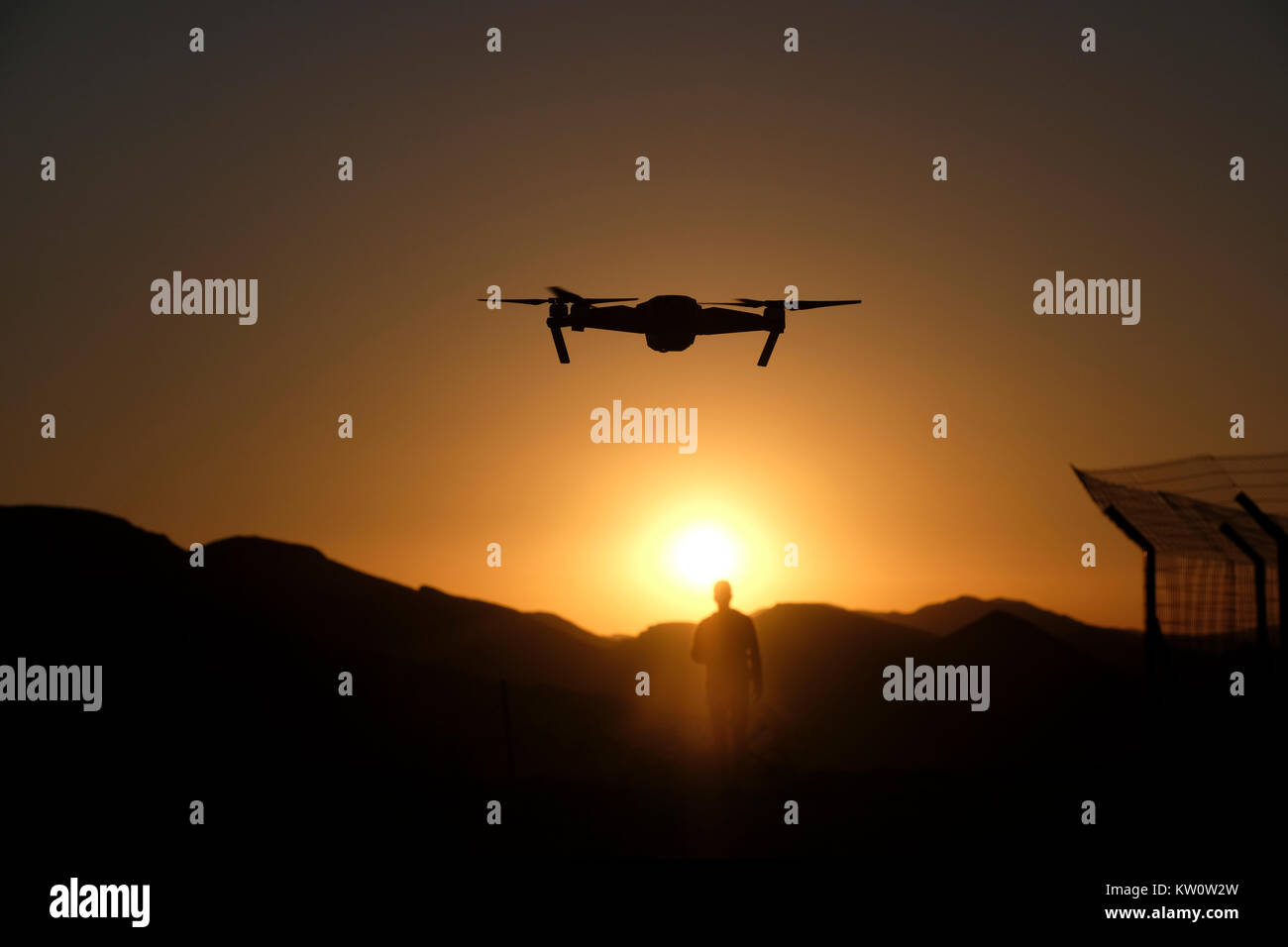 A camera equipped radio controlled quadcopter drone flying over a ...