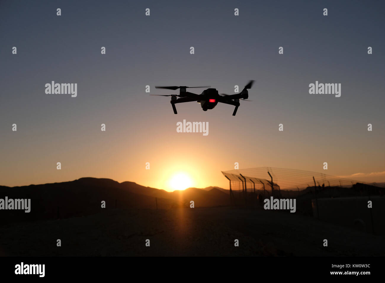 A camera equipped radio controlled quadcopter drone flying over an ...