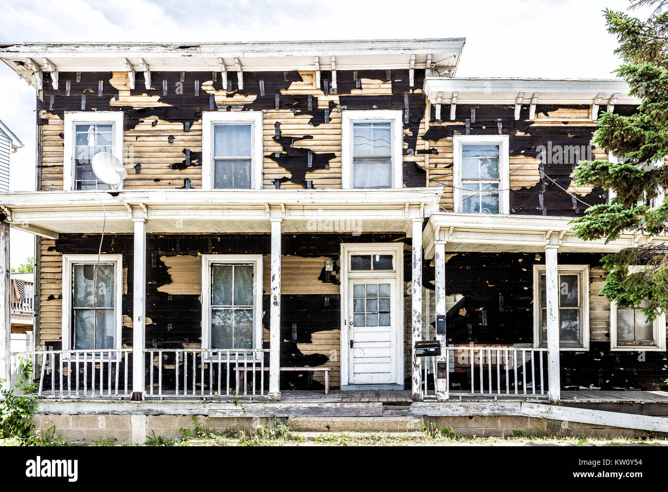 Old abandoned weathered wooden house with porch entrance, peeling paint ...
