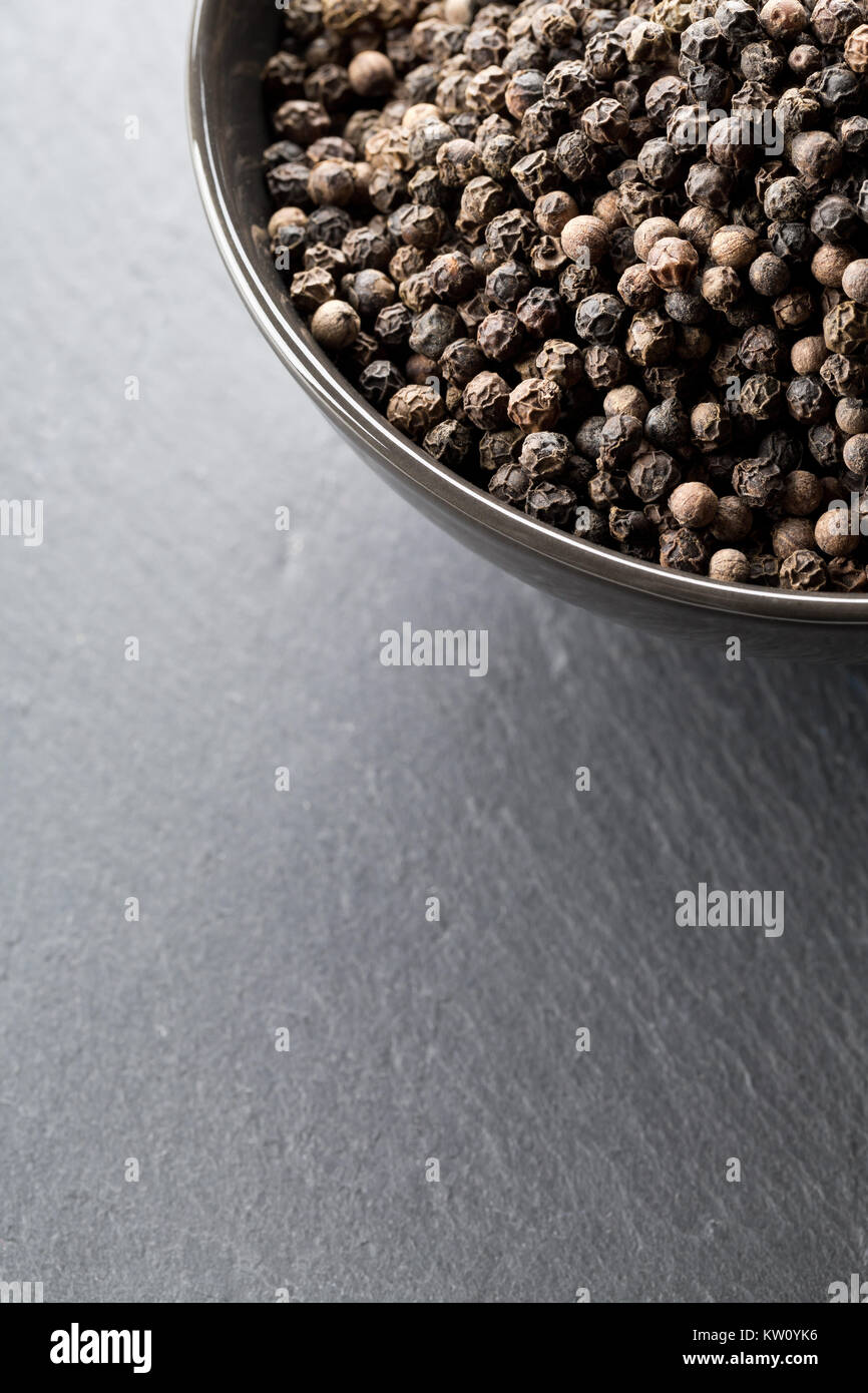 Raw, natural, unprocessed black pepper peppercorns in black bowl on ...