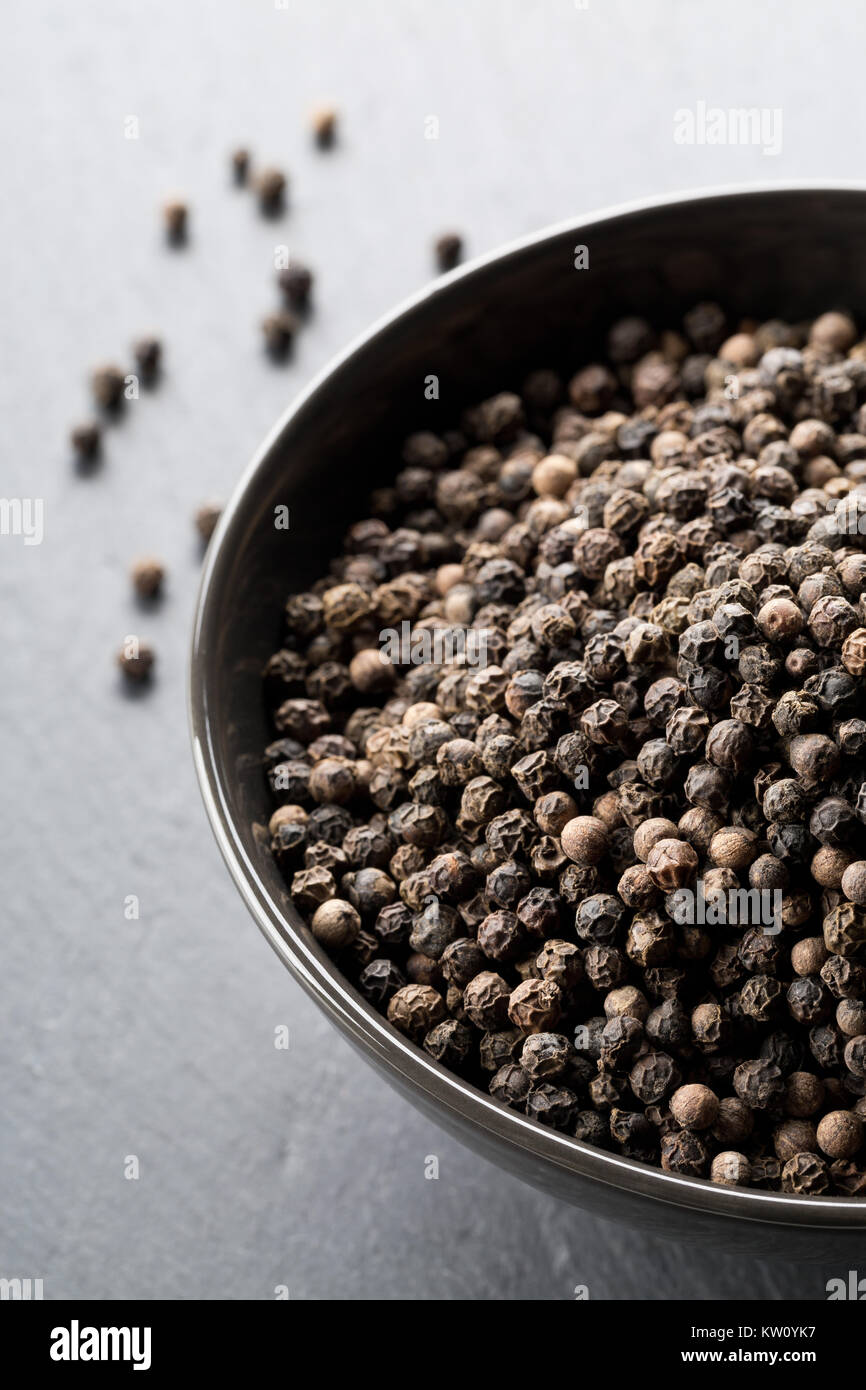 Raw, natural, unprocessed black pepper peppercorns in black bowl on ...
