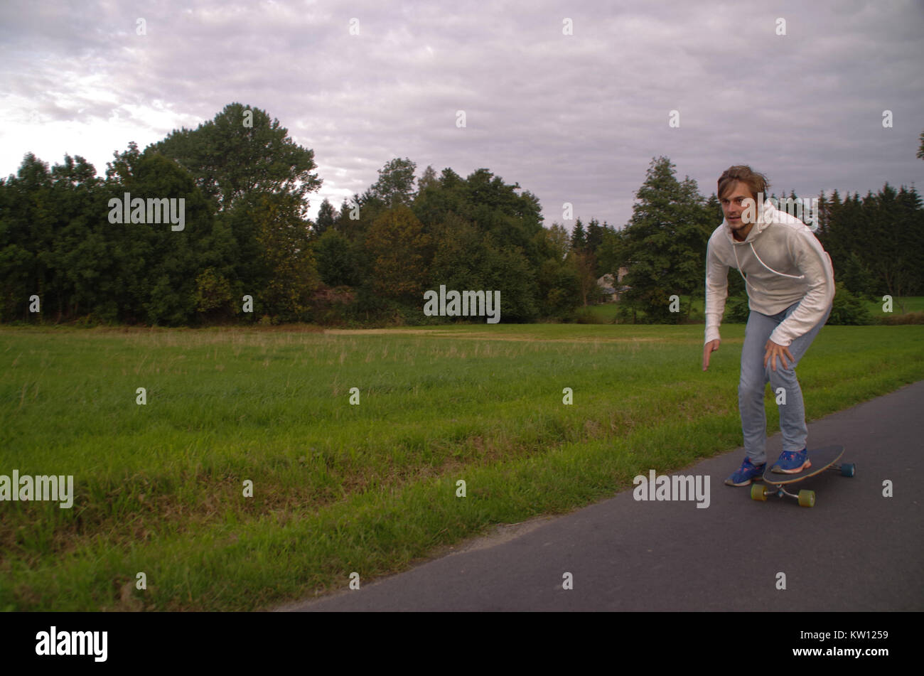 Longboarder going up the hill with speed, horizontal shot with copy ...