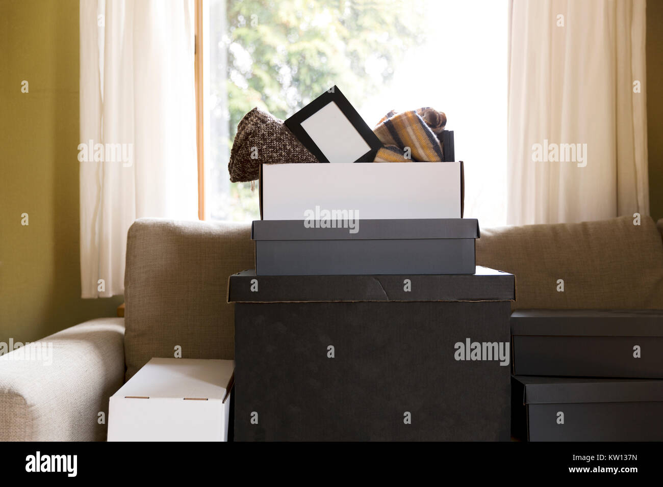 Move house concept. Carton boxes, shoe boxes and belongings on couch ...