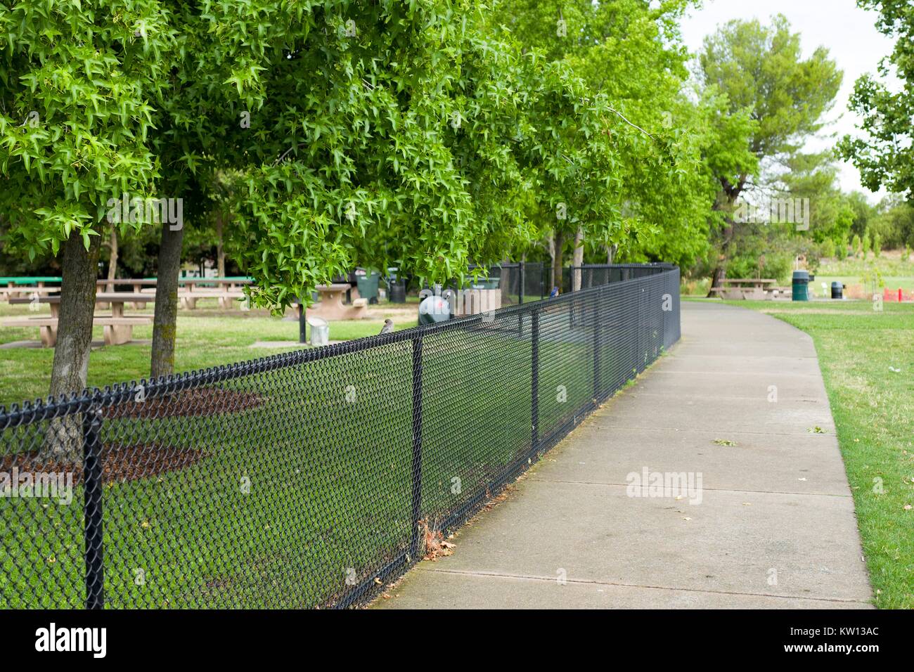 Path and fence enclosing picnic area in Heather Farms Park, a public ...