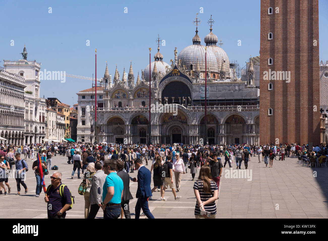 Tourists throng Saint Mark's Square in front of Saint Mark's Basilica ...