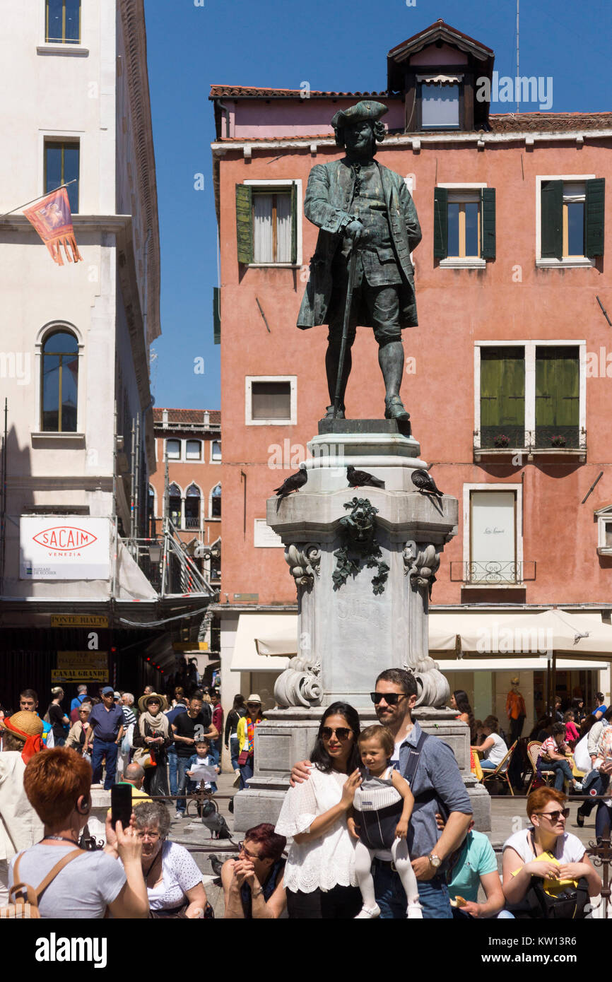 A young family posing in front of the statue of the famous Venetian ...