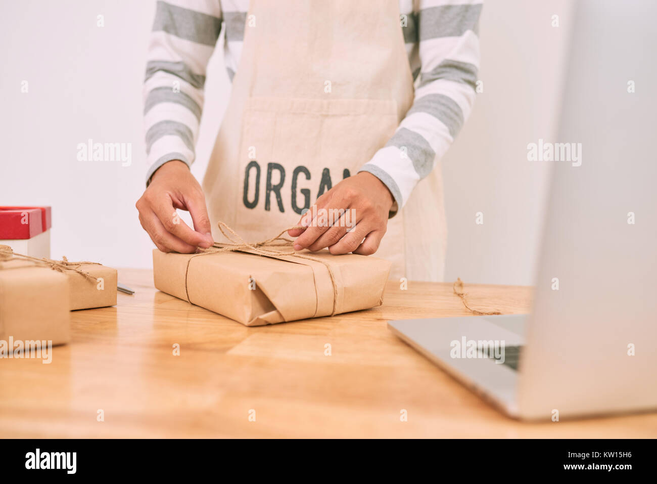 Asian man wrapping purchase while working in shop of gifts Stock Photo ...