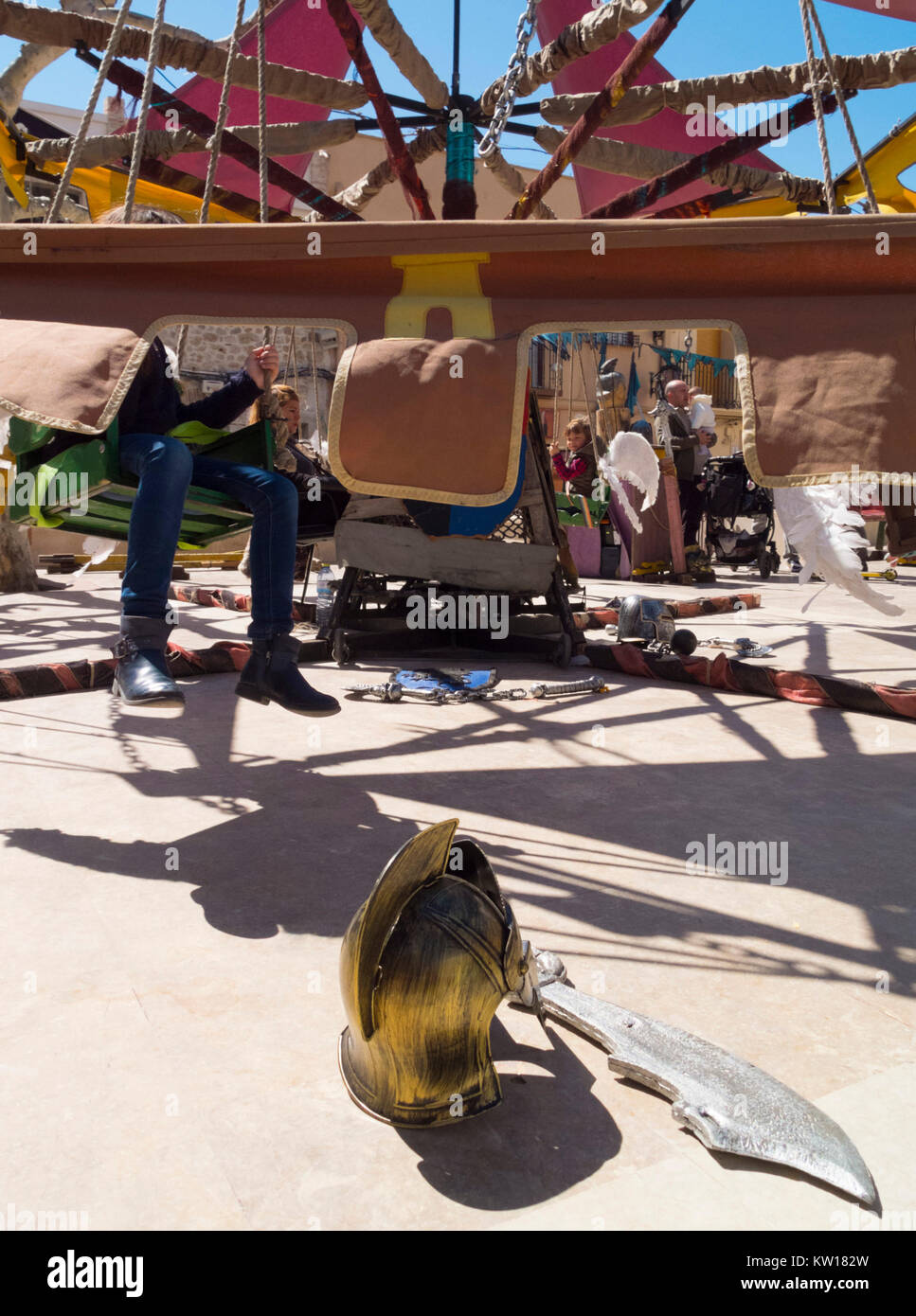 roman helmet and sword in front of medieval childrens carousel during ...