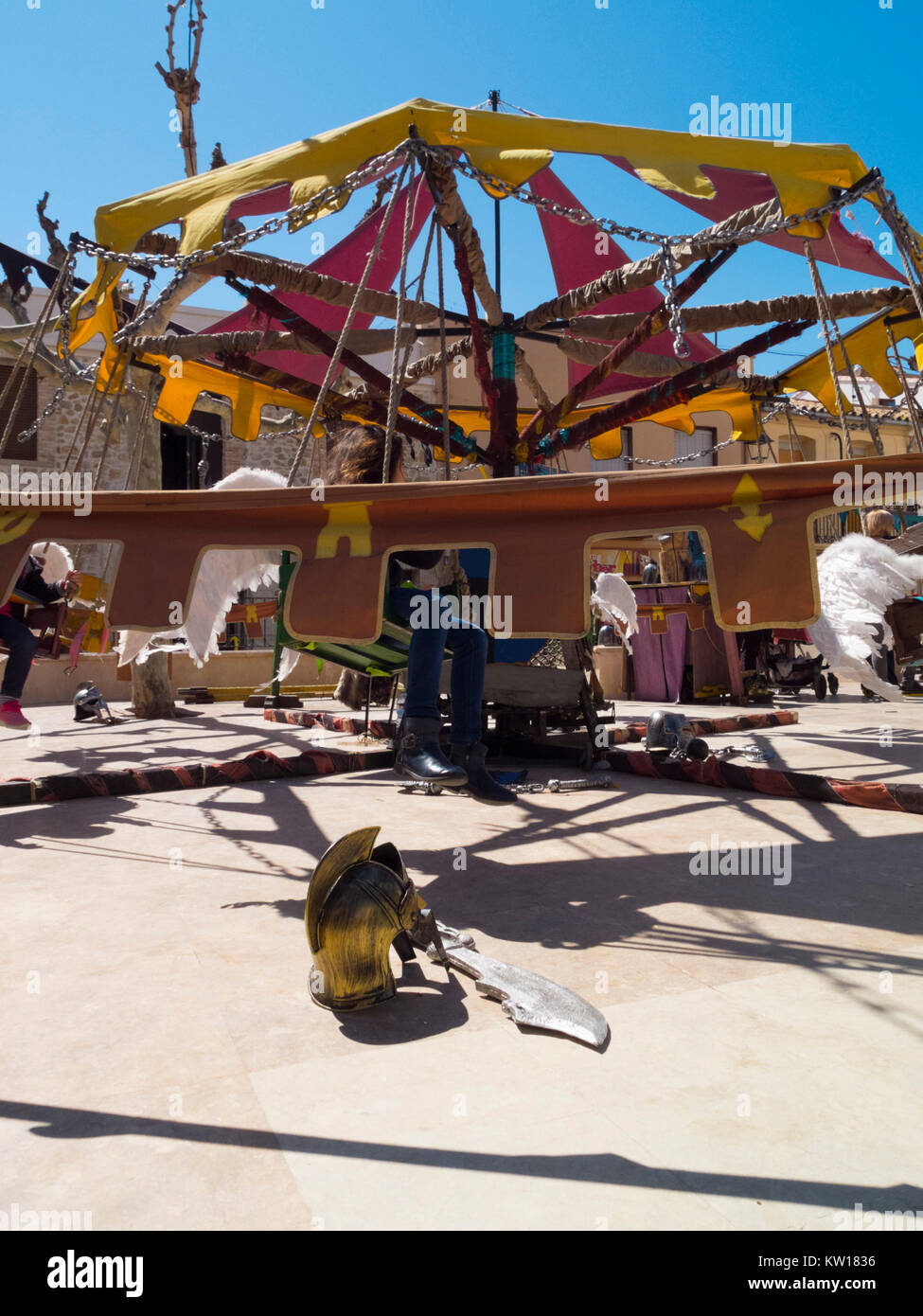 roman helmet and sword in front of medieval childrens carousel during ...