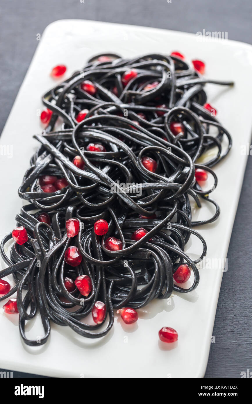 Black pasta with pomegranate seeds Stock Photo - Alamy