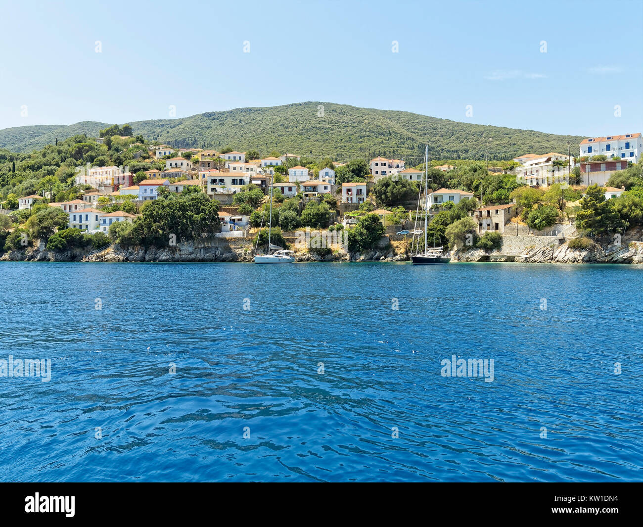 On the shores of the Greek island of Ithika houses nestle amongst trees on the hillside while ...