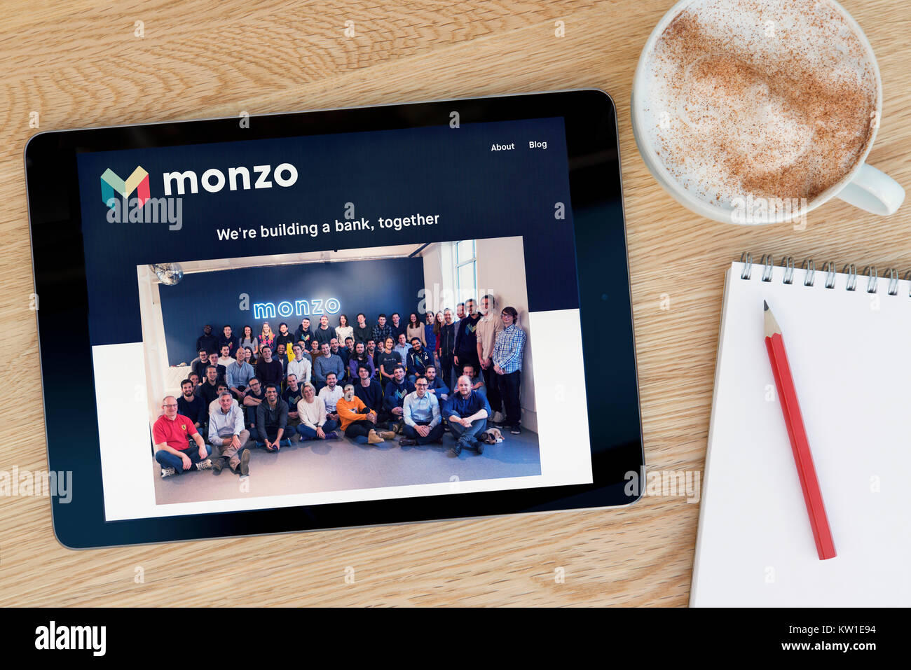The Monzo Bank website on an iPad tablet device, resting on a wooden ...