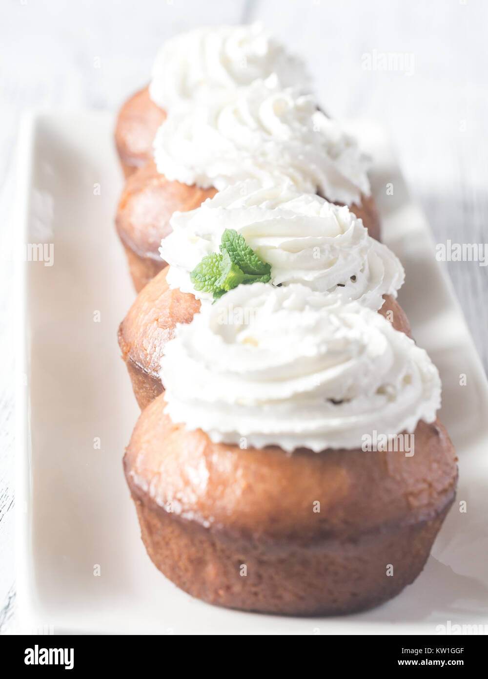 Rum baba on the plate arranged in a row Stock Photo - Alamy