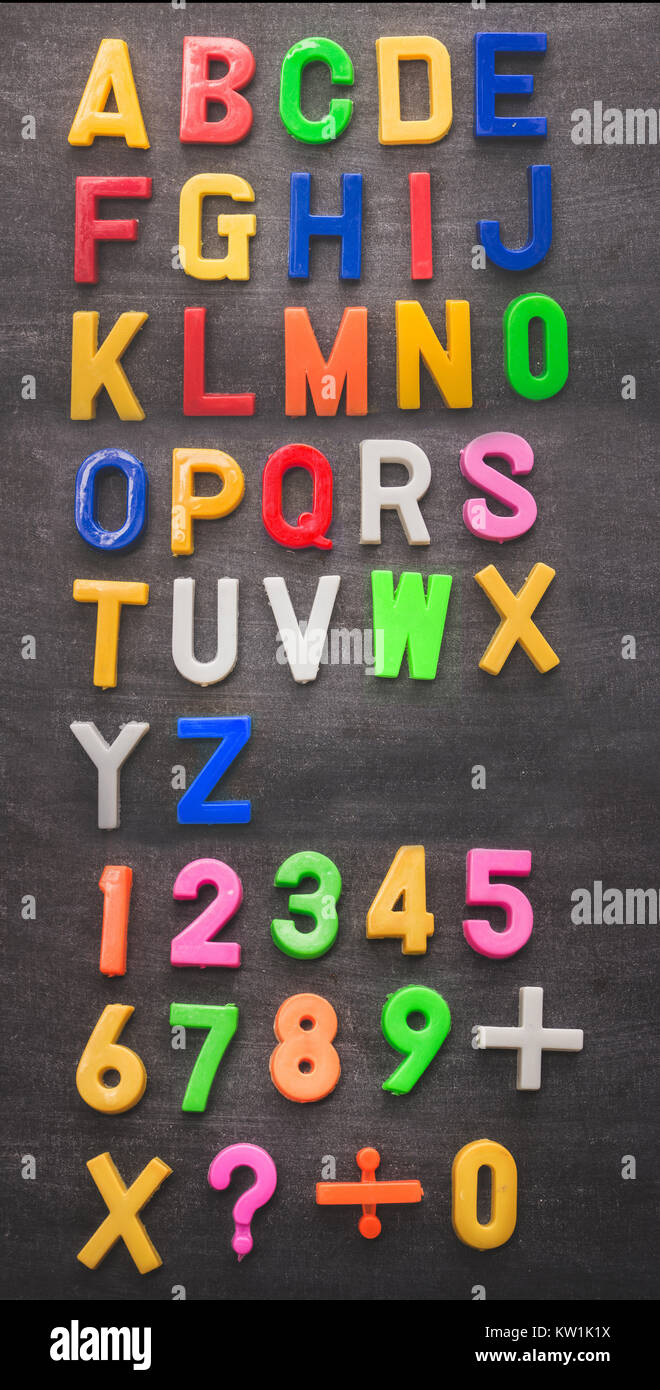 colorful plastic alphabet on black board background Stock Photo - Alamy