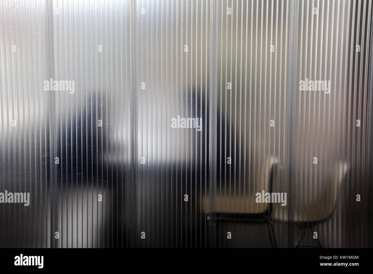 couple sitting behind half transparent screen Stock Photo - Alamy