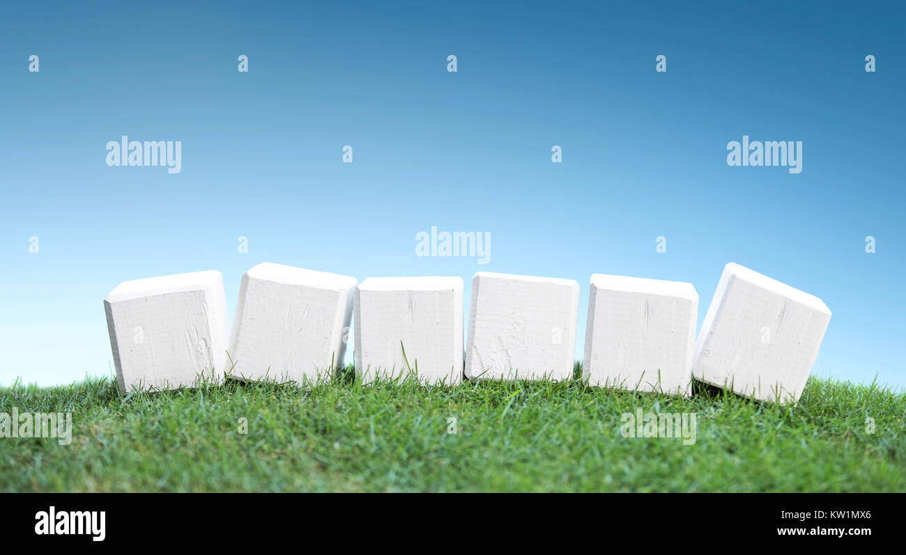 Wooden blocks on a green grass, plain white Stock Photo - Alamy