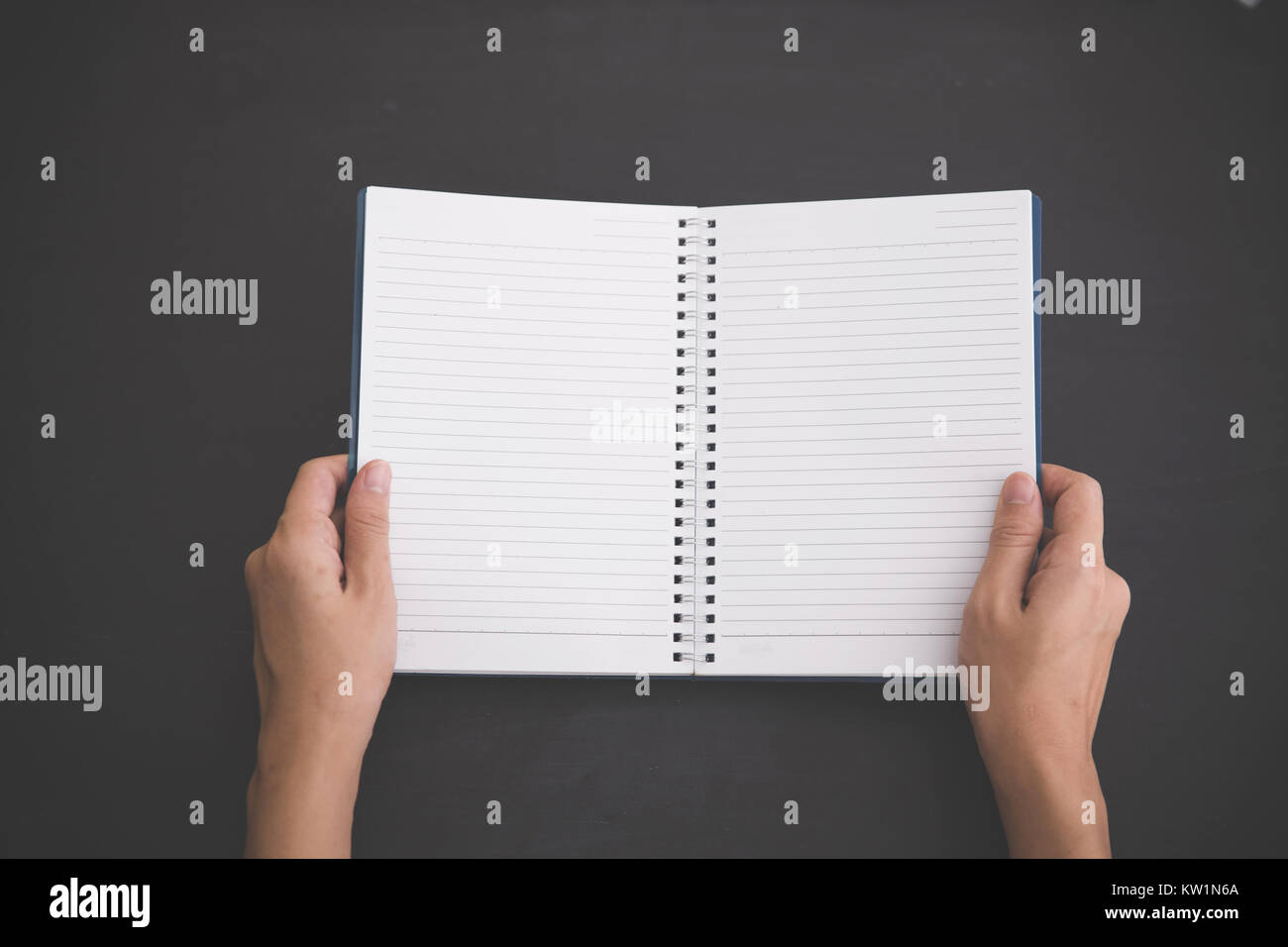 Hand open a notebook, black background. Mock up Stock Photo - Alamy