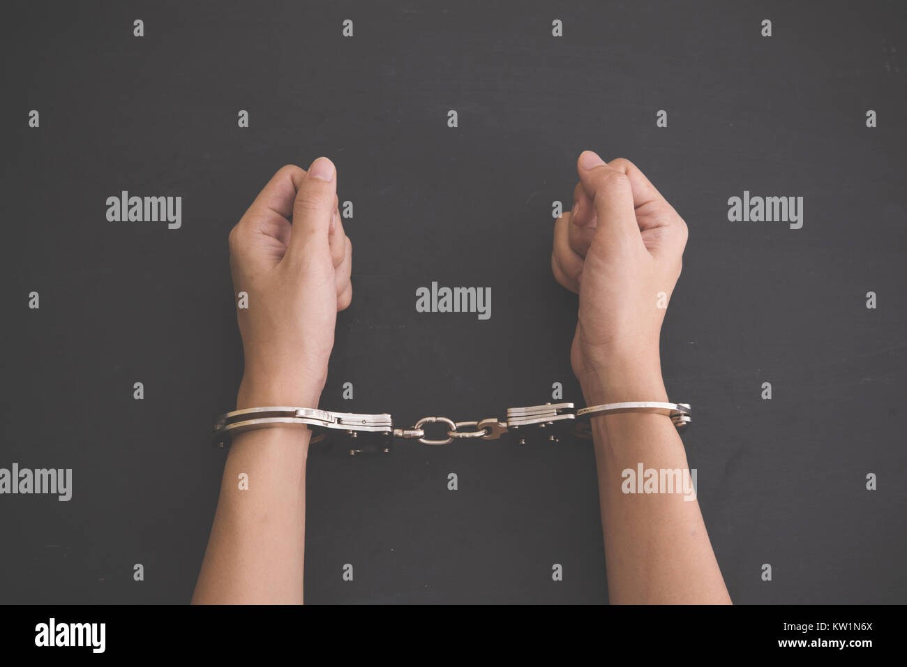 Hands with handcuffs on black background Stock Photo - Alamy