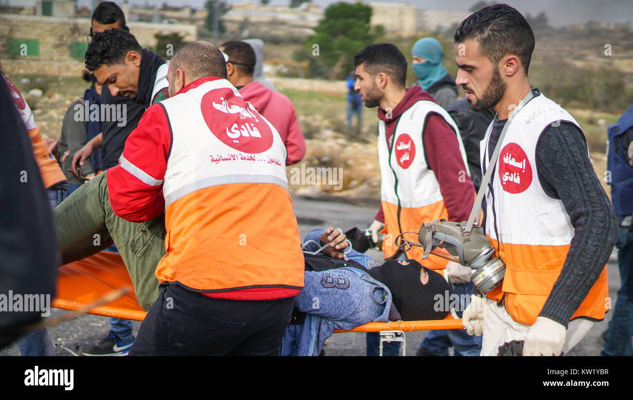 Palestinian medics carry a wounded Palestinian stone thrower during ...