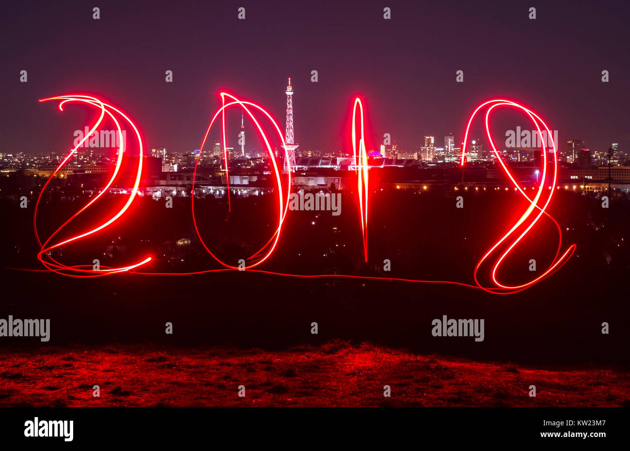 Berlin, Germany. 29th Dec, 2017. A man traces out "2018" using a torch ...