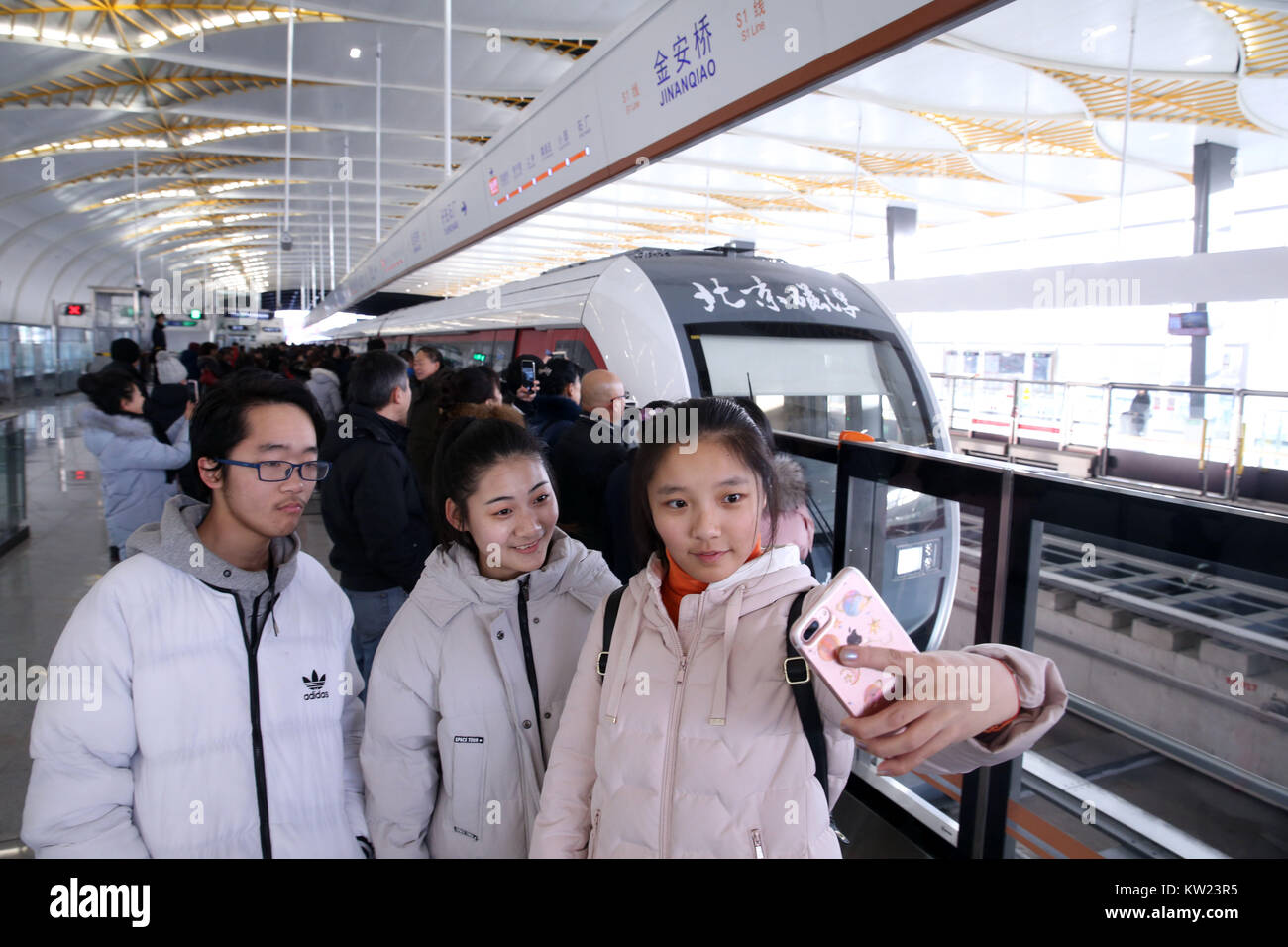 Beijing, China. 30th Dec, 2017. Passengers take selfie in front of a ...