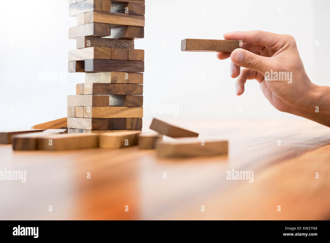 Business man placing wooden block on a tower concept of risk control ...