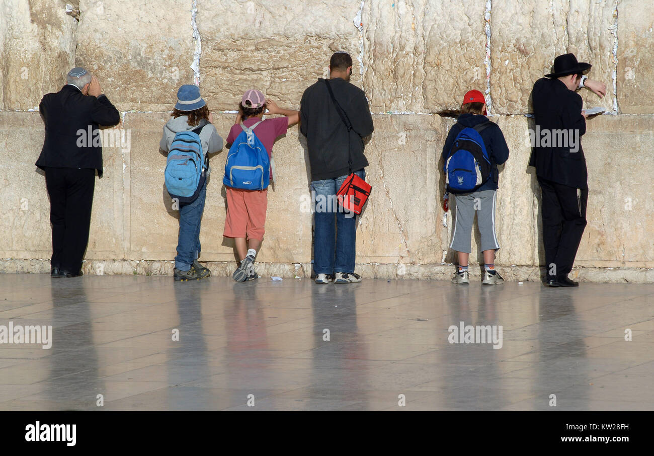 Mens Jews in traditional national black clothes and boys stand and pray ...
