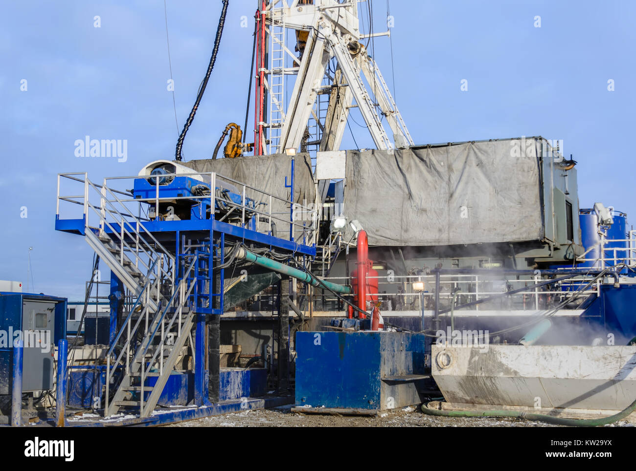 Drilling an oil well drilling rig in winter in a field with a blue sky ...