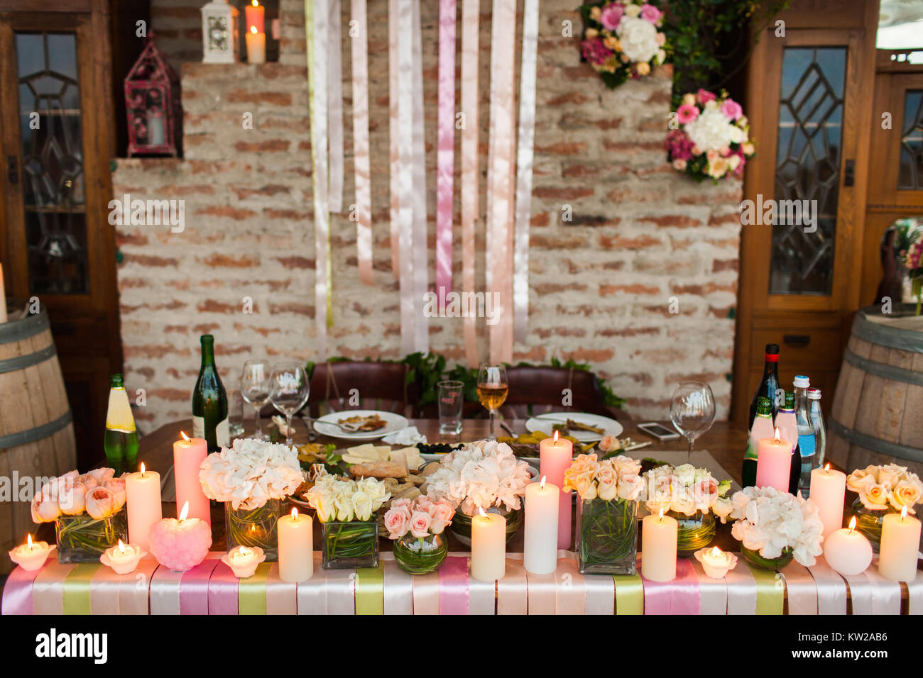 The flowers, candles and colored ribbons on the wedding table Stock ...