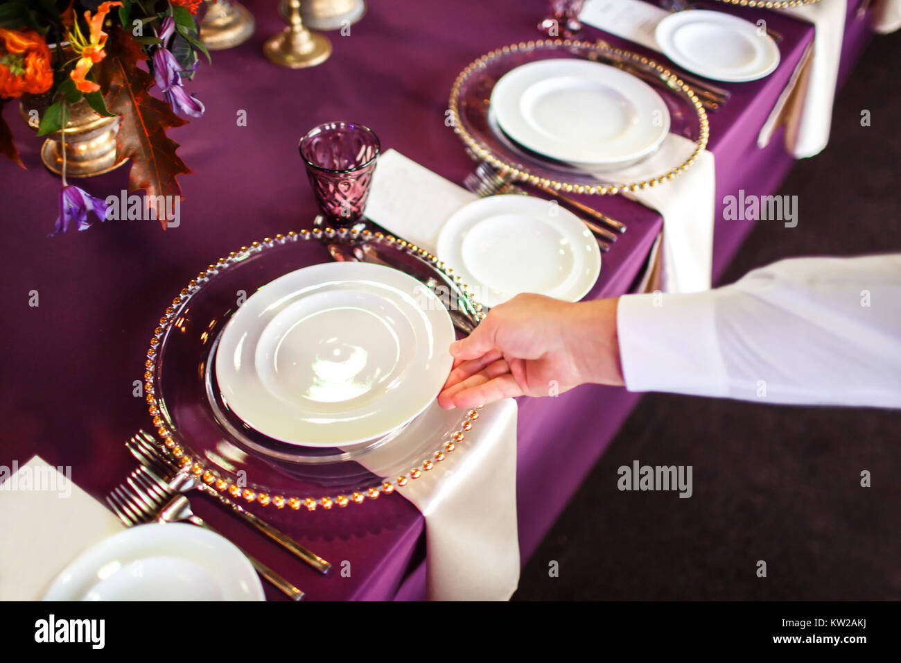 The waiter puts the plate on the table Stock Photo - Alamy