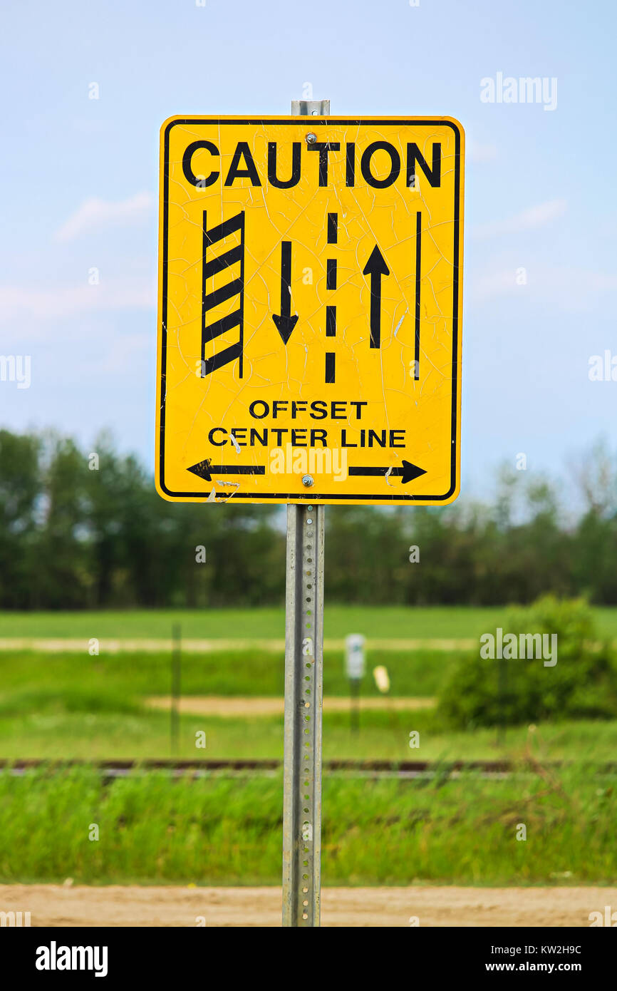 A caution offset center line road sign Stock Photo - Alamy