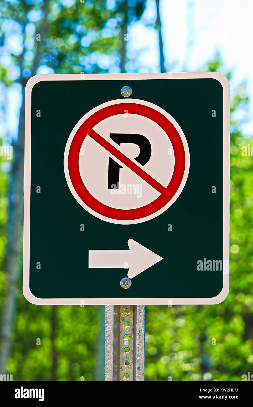 A green no parking right sign with trees in the background Stock Photo ...