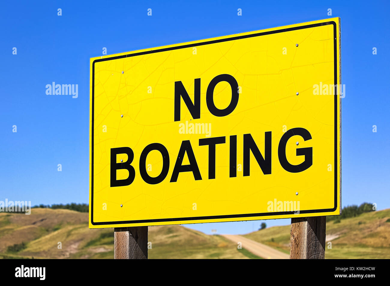 A yellow no boating sign against a blue sky Stock Photo - Alamy