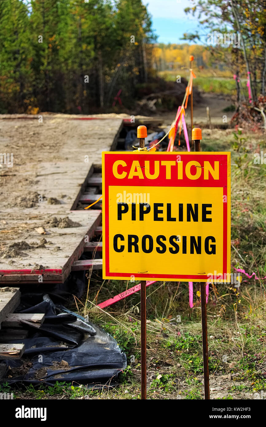 Closeup of a caution pipeline crossing sign Stock Photo - Alamy