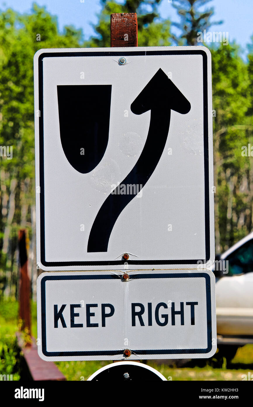 A keep right information sign with trees in the background Stock Photo ...