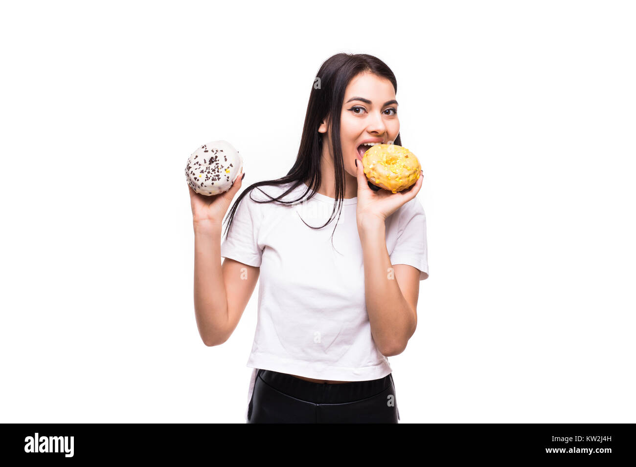 Close up portrait of a hungry greedy girl eating donuts isolated over ...