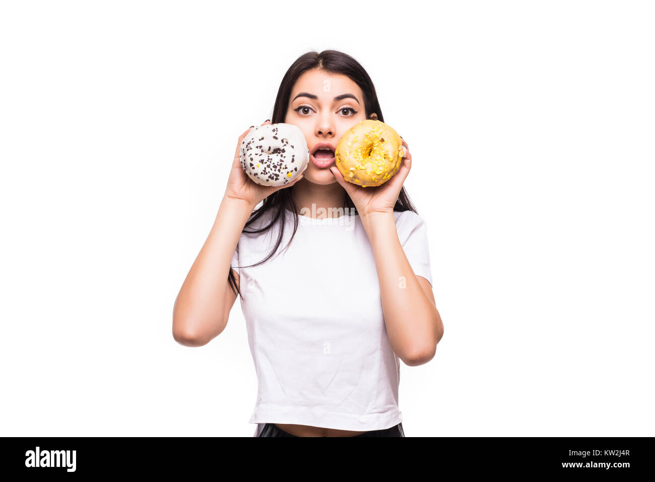 Portrait of a cheerful pretty girl holding donuts at her face isolated ...