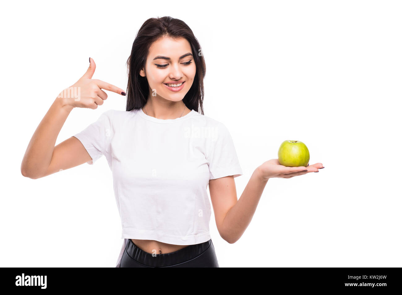 Portrait of a smiling pretty girl holding an apple and pointing finger ...